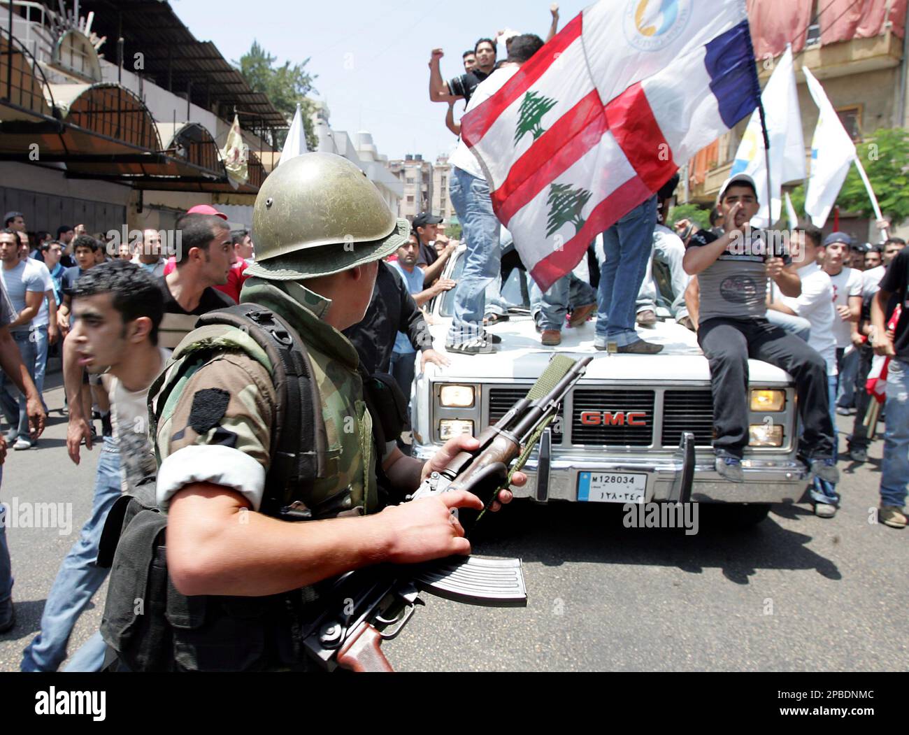 A Lebanese army soldier looks to anti-syria supporters who wave ...