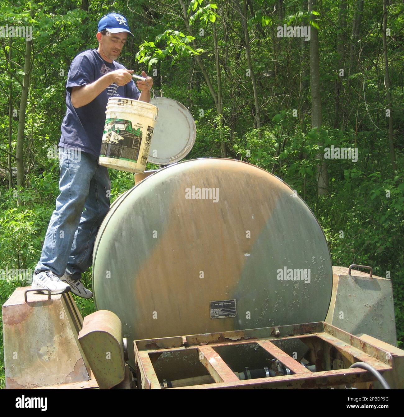 Roger Thacker draws a bucket of water from a "buffalo tank" May 15 ...