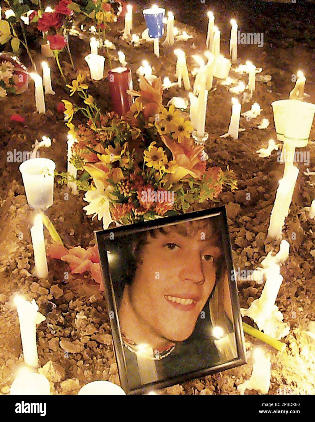 A picture of Zachary Jones sits among flowers and dozens of candles during a memorial ceremony ...