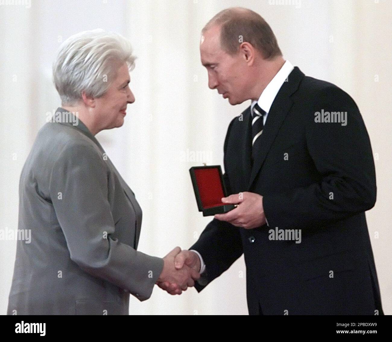 Russian President Vladimir Putin, right hands over to Natalya ...