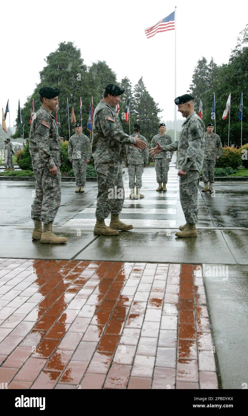 As rain falls, Lt. Gen. Charles Jacoby Jr., right, shakes hands with ...