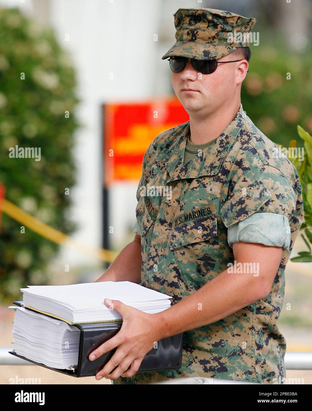 Marine Corps Lance Cpl. Justin Sharratt carries documents as he arrives ...