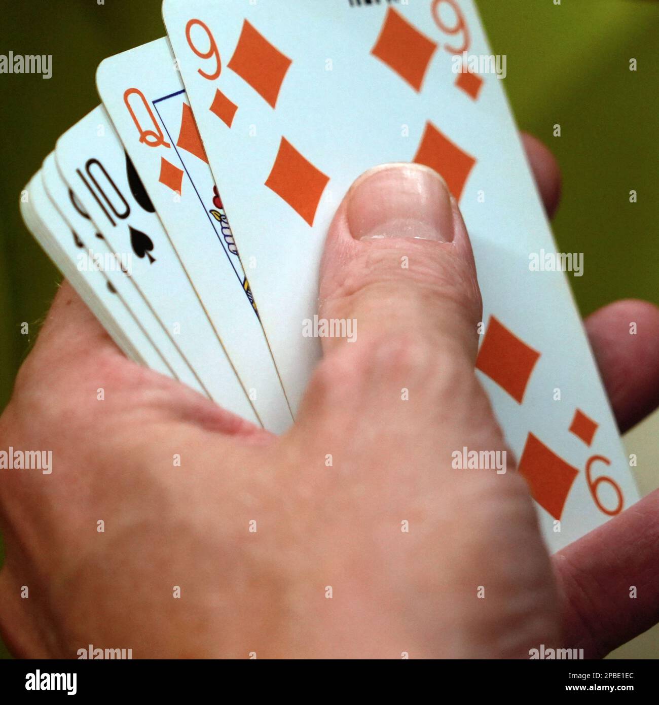 Playing cards in a man's hand during a bridge game Stock Photo - Alamy