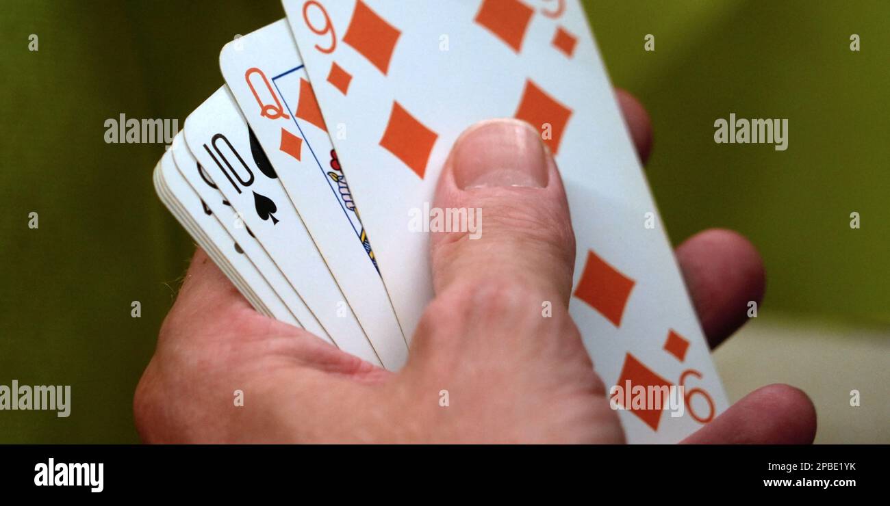 Playing cards in a man's hand during a bridge game Stock Photo - Alamy
