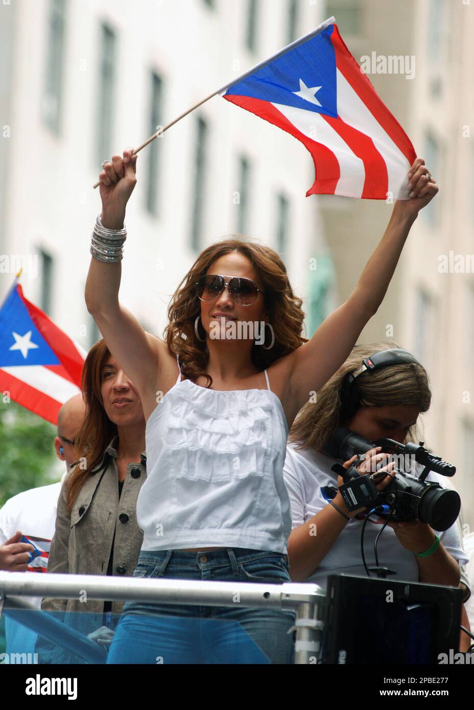 Jennifer Lopez waves a Puerto Rican flag as she rides along Fifth ...
