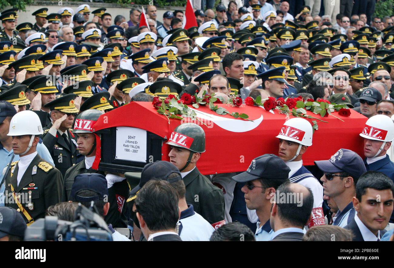 A military guard of honour carry the flag-covered coffin of Kadir ...