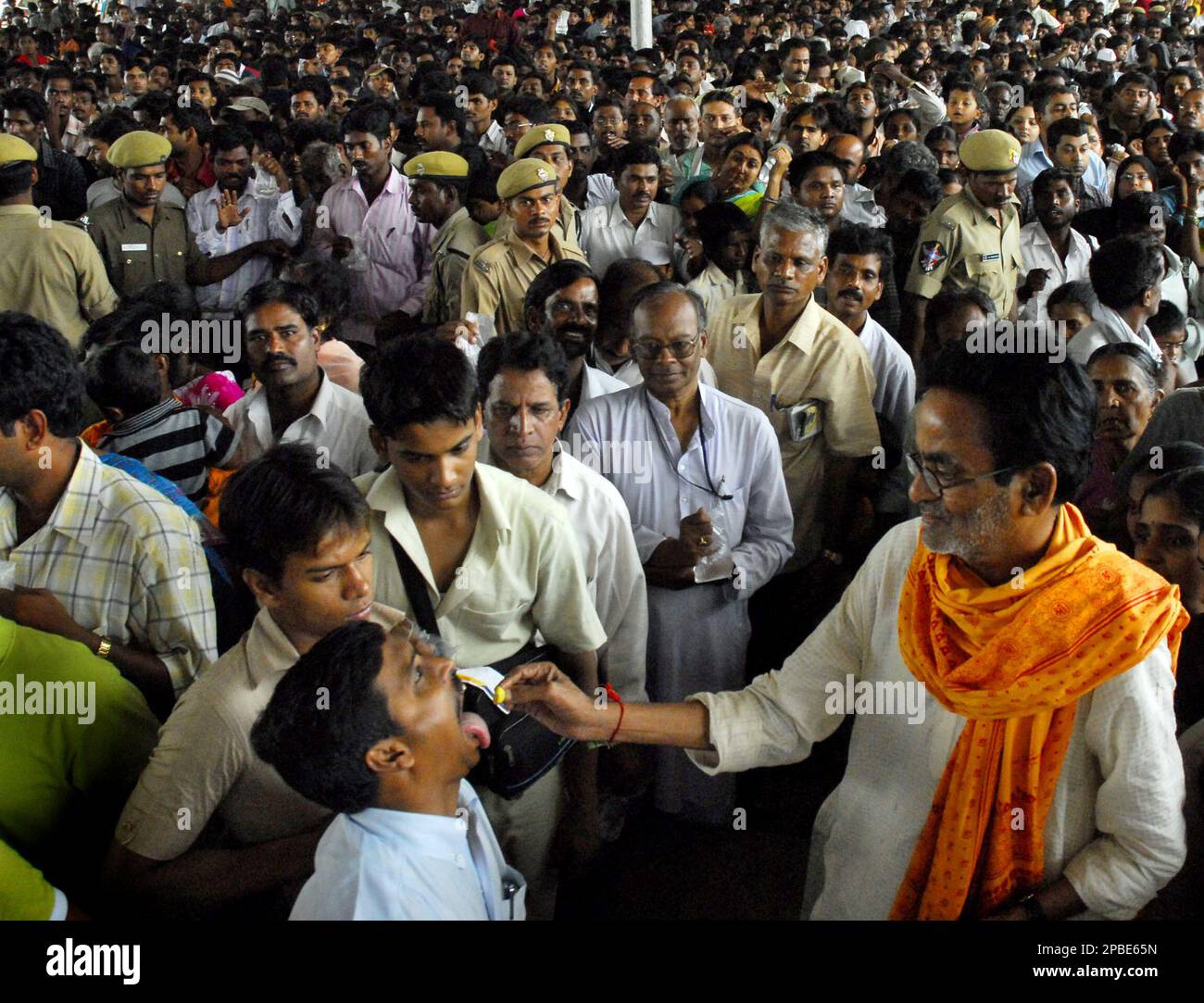 A member of the Bathini Goud family, right, administers a live fish ...