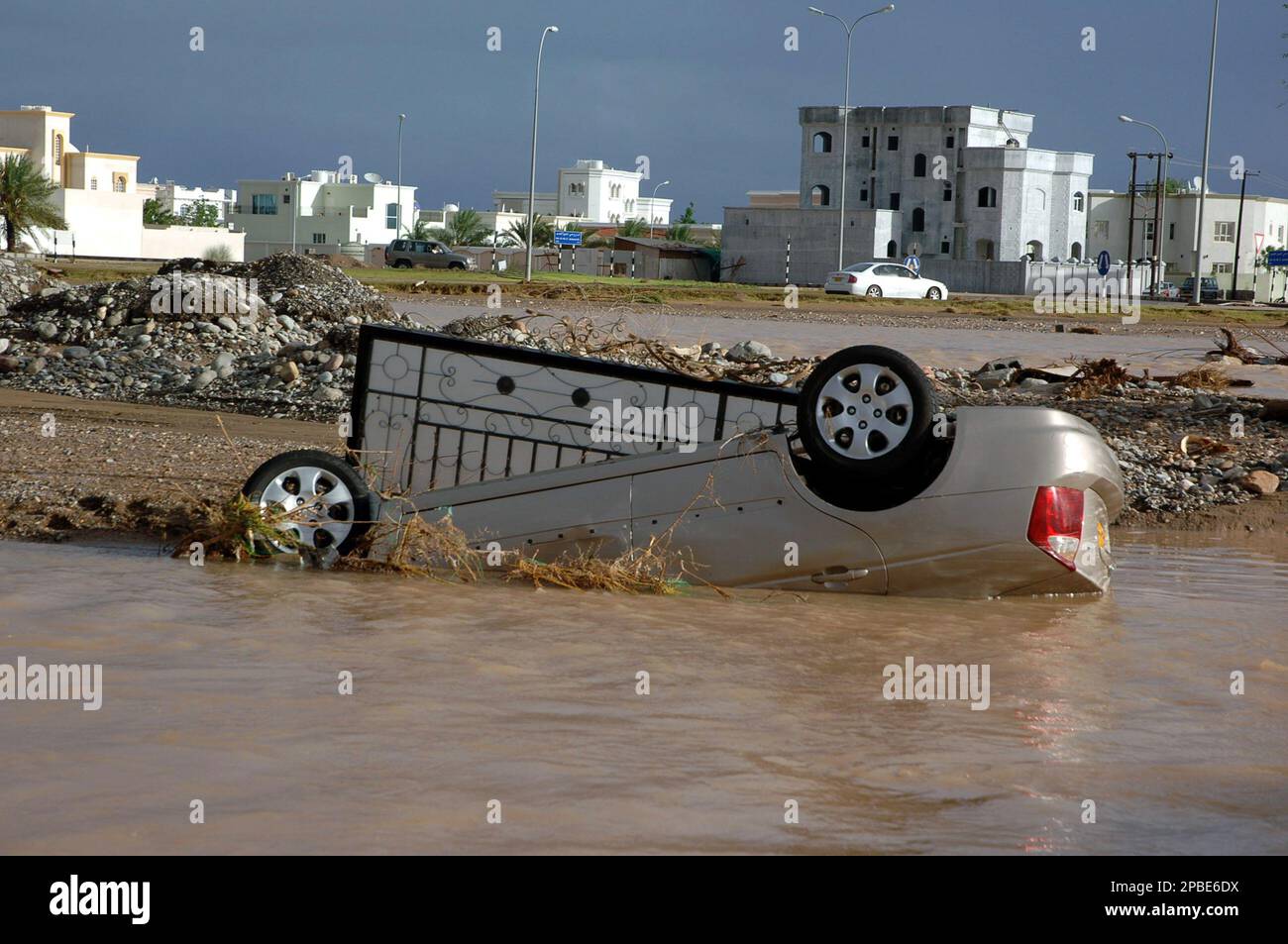 Debris is strewn around an overturned car in Muscat, Sultanate of Oman ...