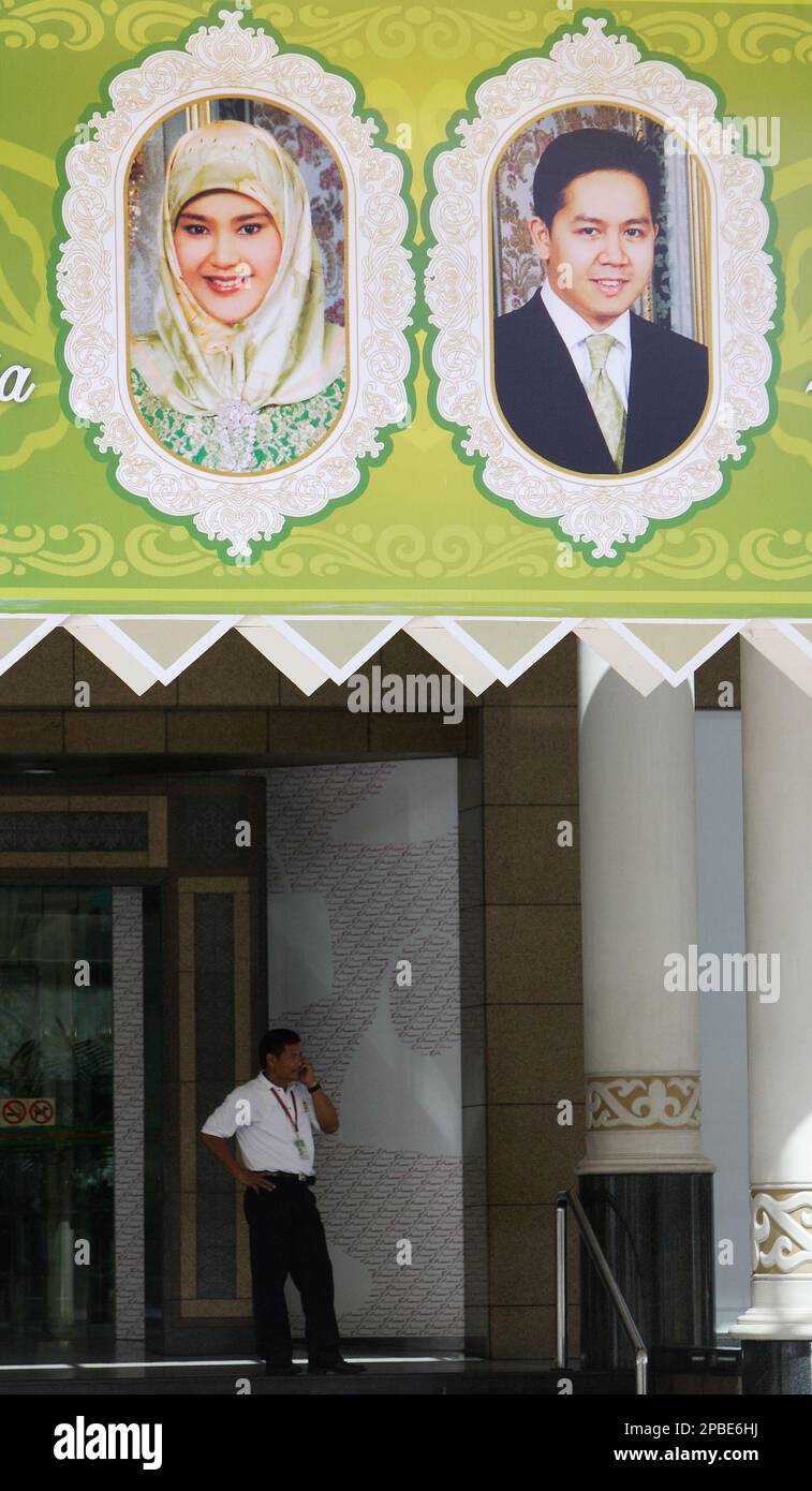 A man makes a phone call under a banner bearing portraits of Princess ...