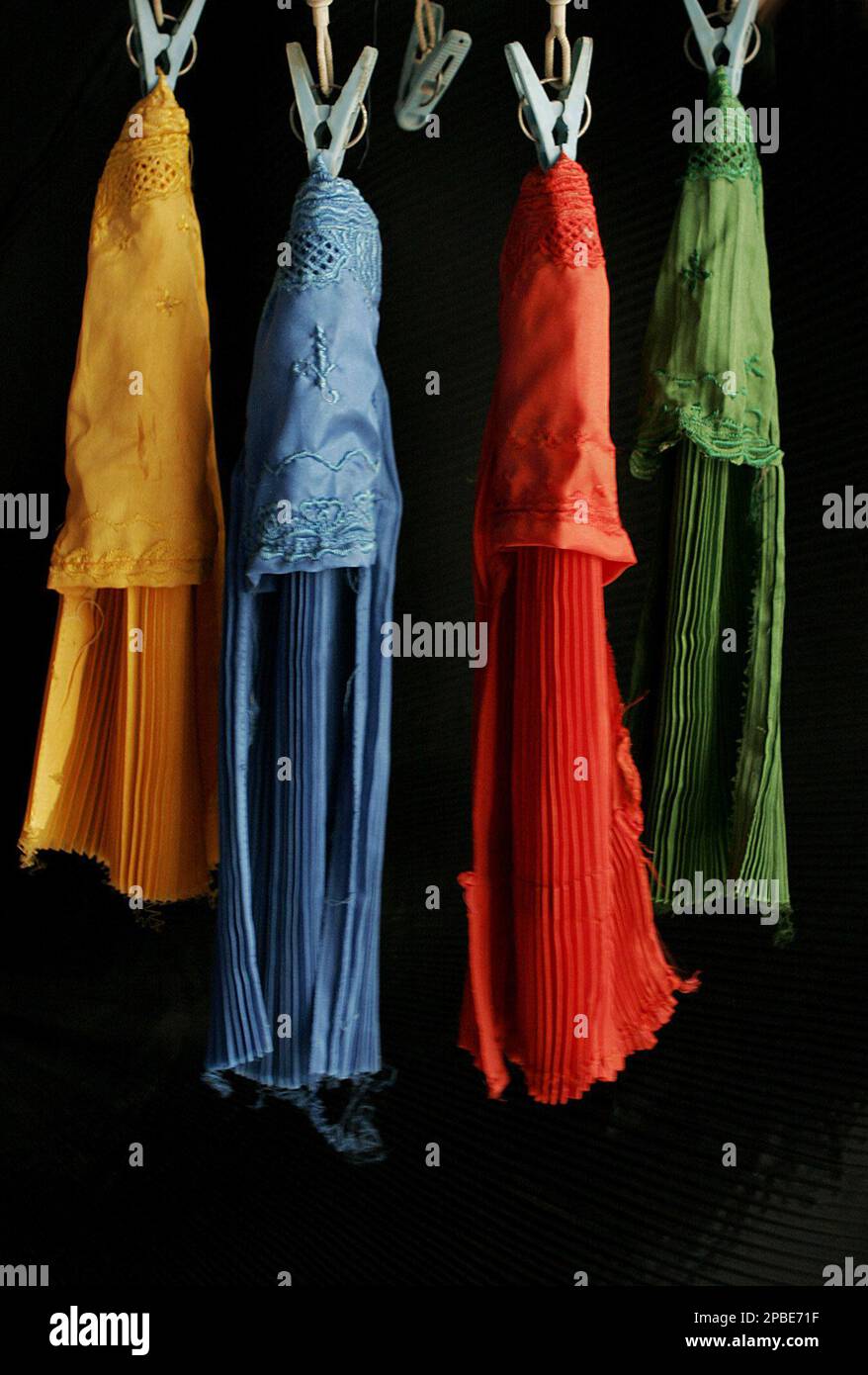 Small burqas in different colors hang in a burqa shop as decoration in ...