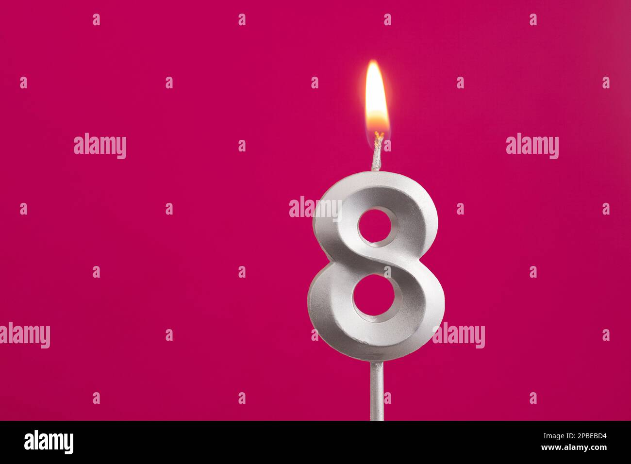 Candle number 8 - Birthday in rhodamine red background Stock Photo - Alamy