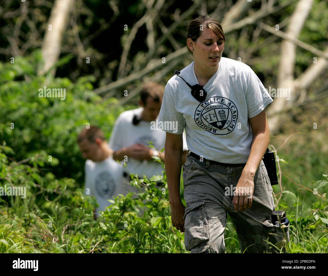 Police recruits comb a wooded area along the Little Blue River in ...