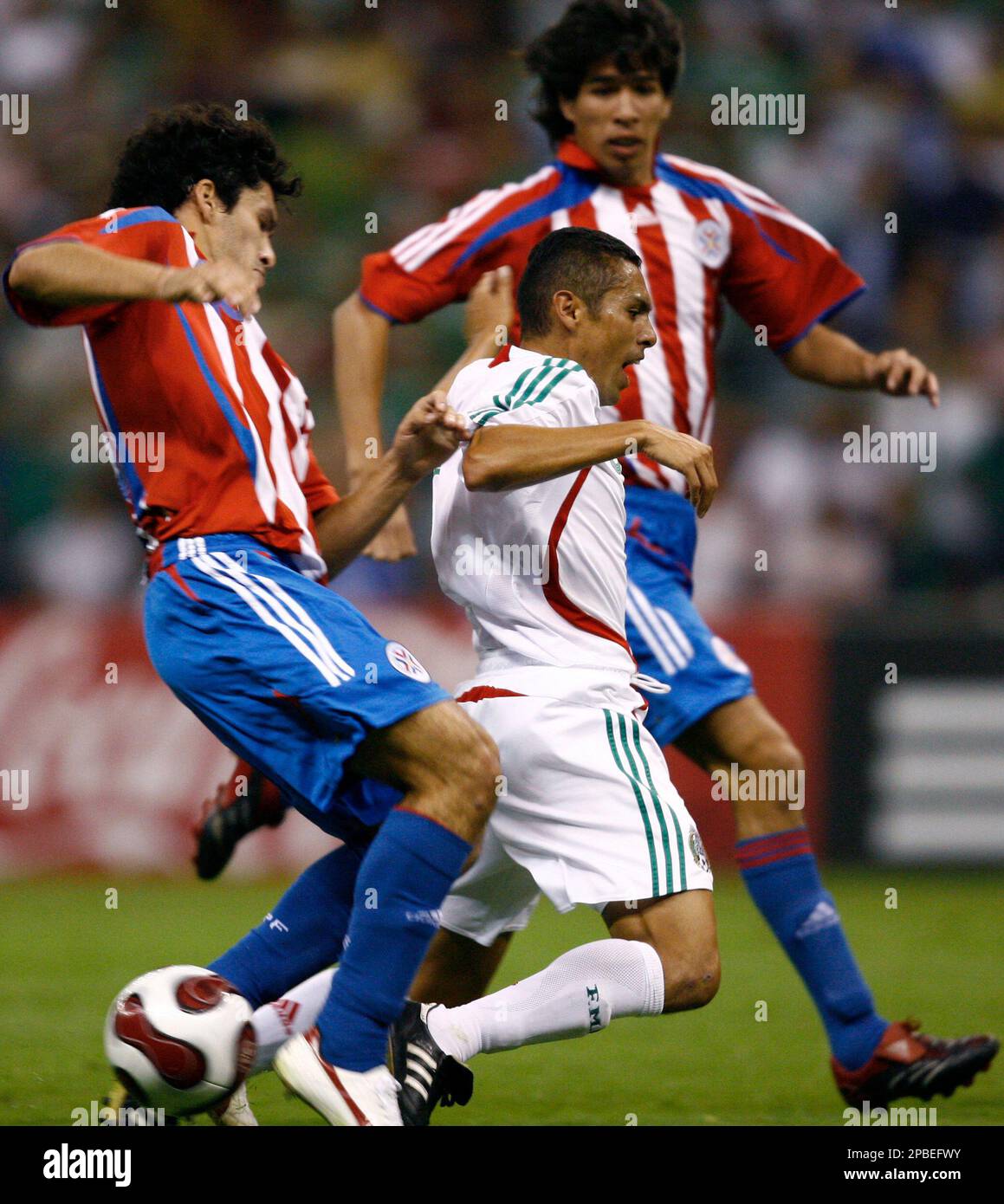 Mexico's Ramon Morales, center is fauled by Paraguay's Cristian Riveros ...