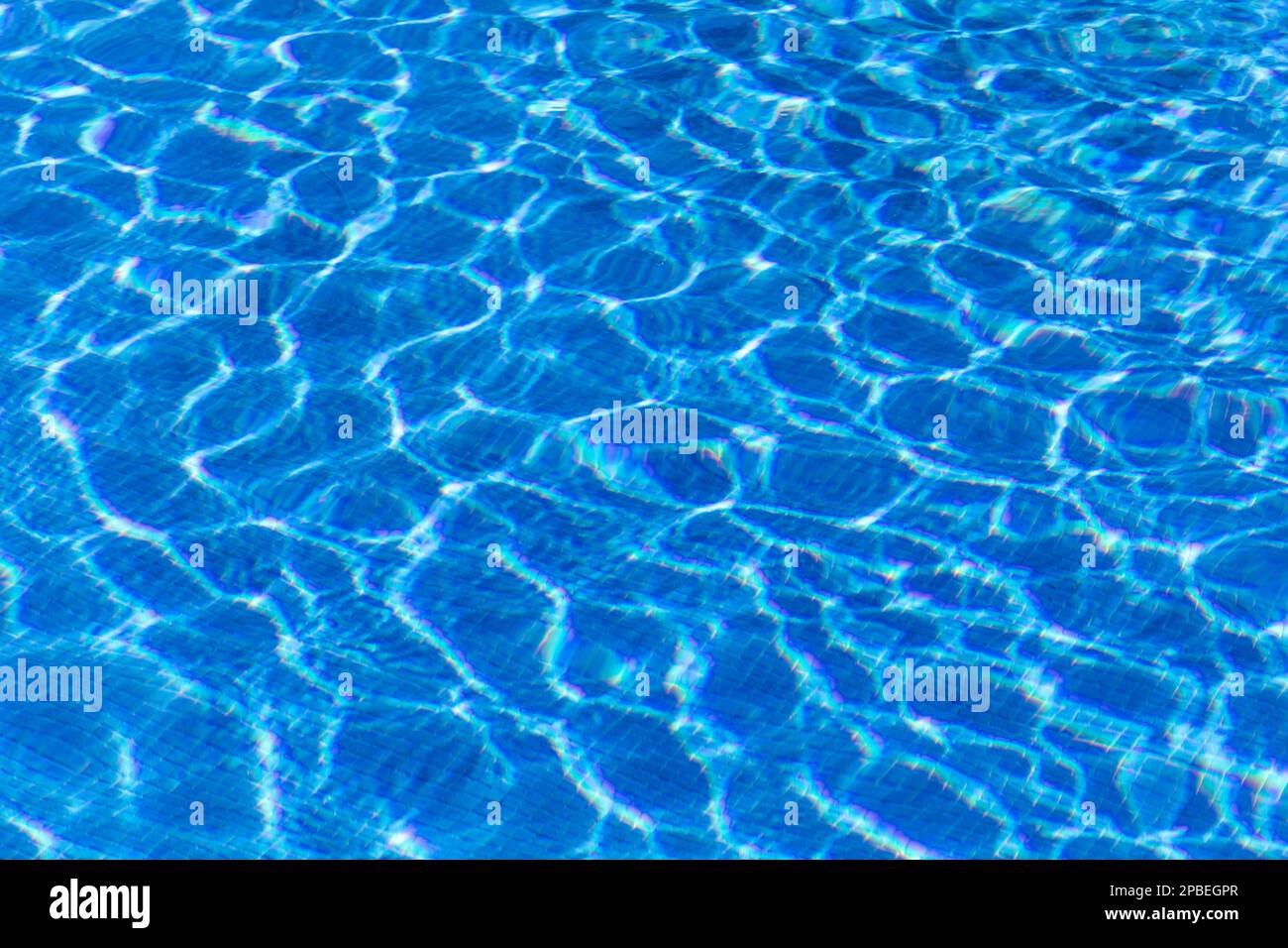 Beautiful blue water in a tiled pool reflecting sunlight and glistening ...