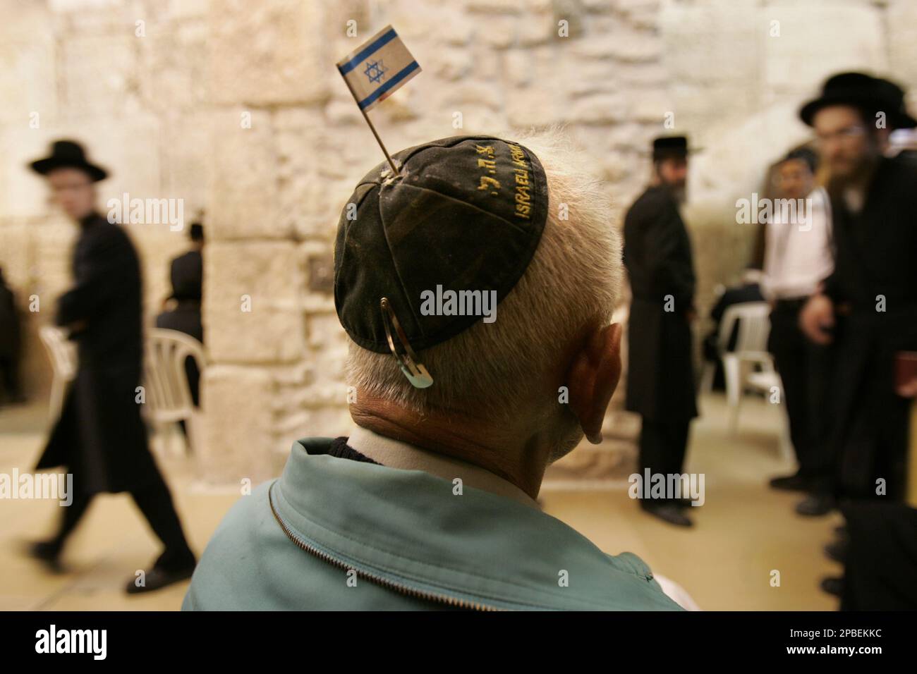A Jewish man wears a small Israeli flag in his skull-cap as he sits at ...