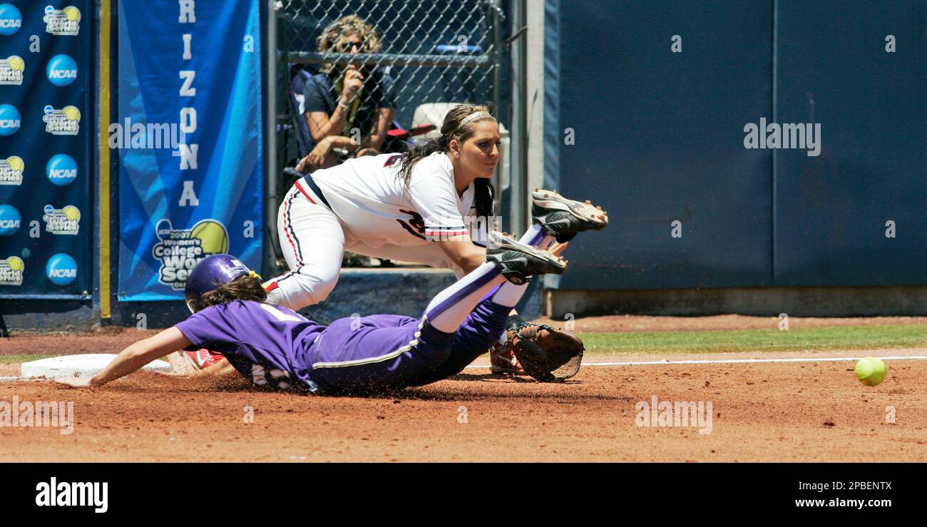 Washington's Lauren Greer, front, slides safely into third base as ...