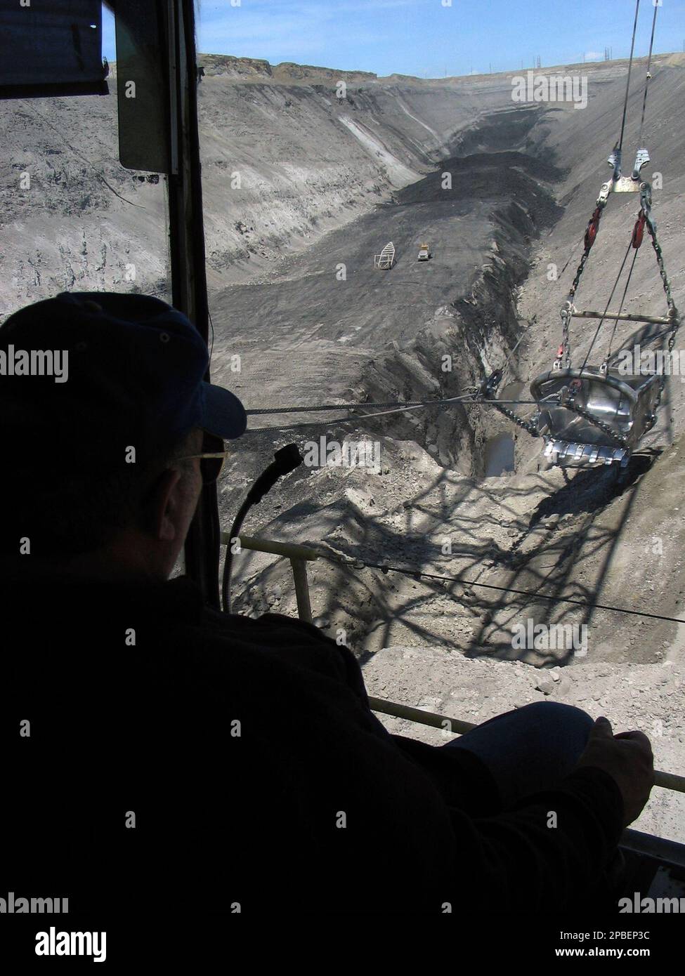 A dragline operator scrapes away dirt and rocks to expose a 70-foot ...