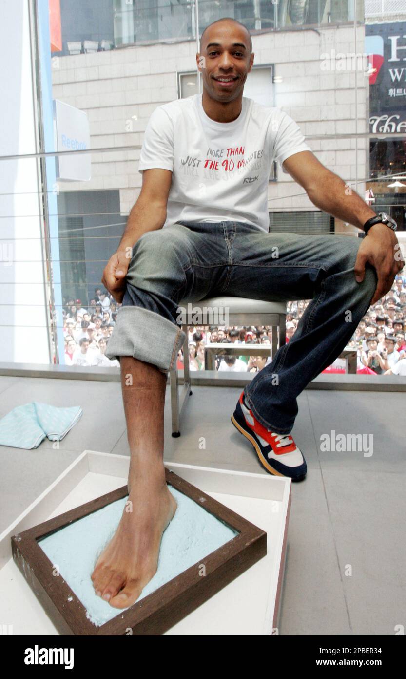 French football star Thierry Henry makes his foot print in wet cement ...