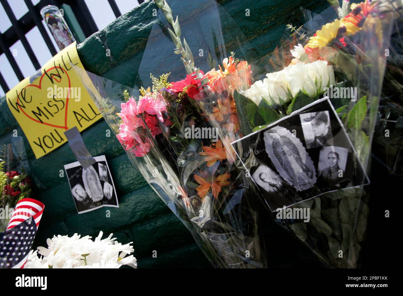 Flowers, candles and messages adorn a sidewalk memorial to three Perris ...