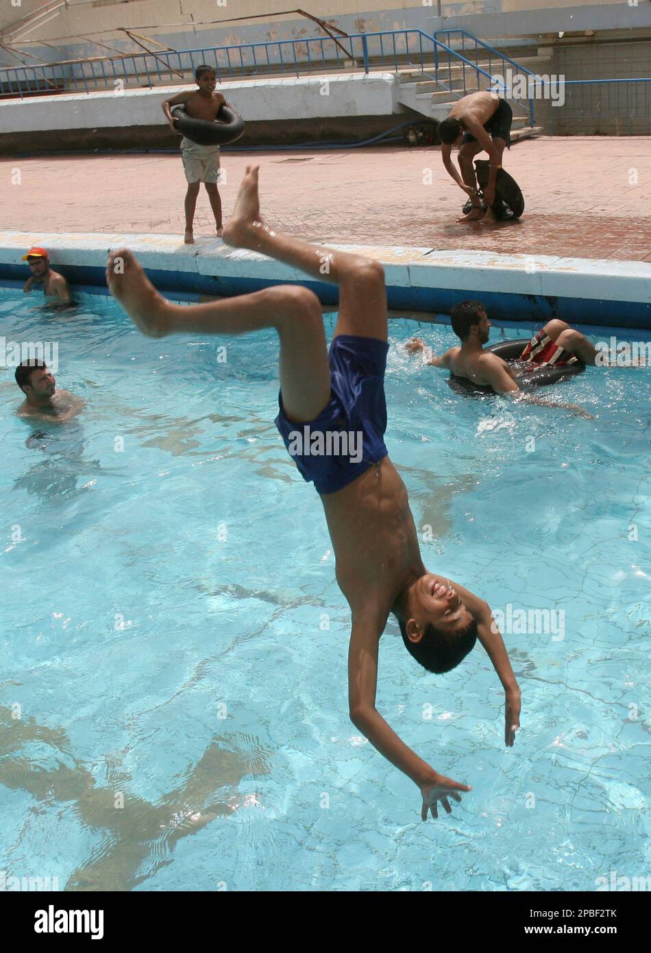 A young Iraqi boy takes advantage of the hot weather as he dives into a ...