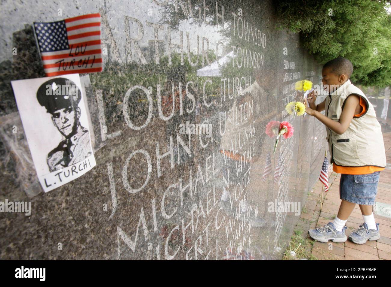 After a Memorial Day ceremony, Jamal Payne, 10, makes a tracing of his ...