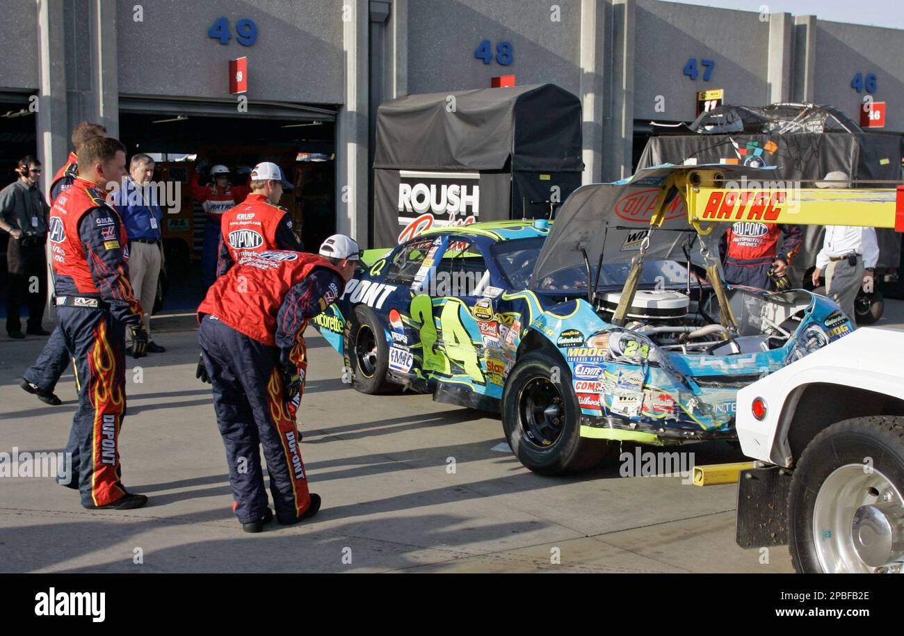 Crew members examine the damage to Jeff Gordon's car after a crash ...