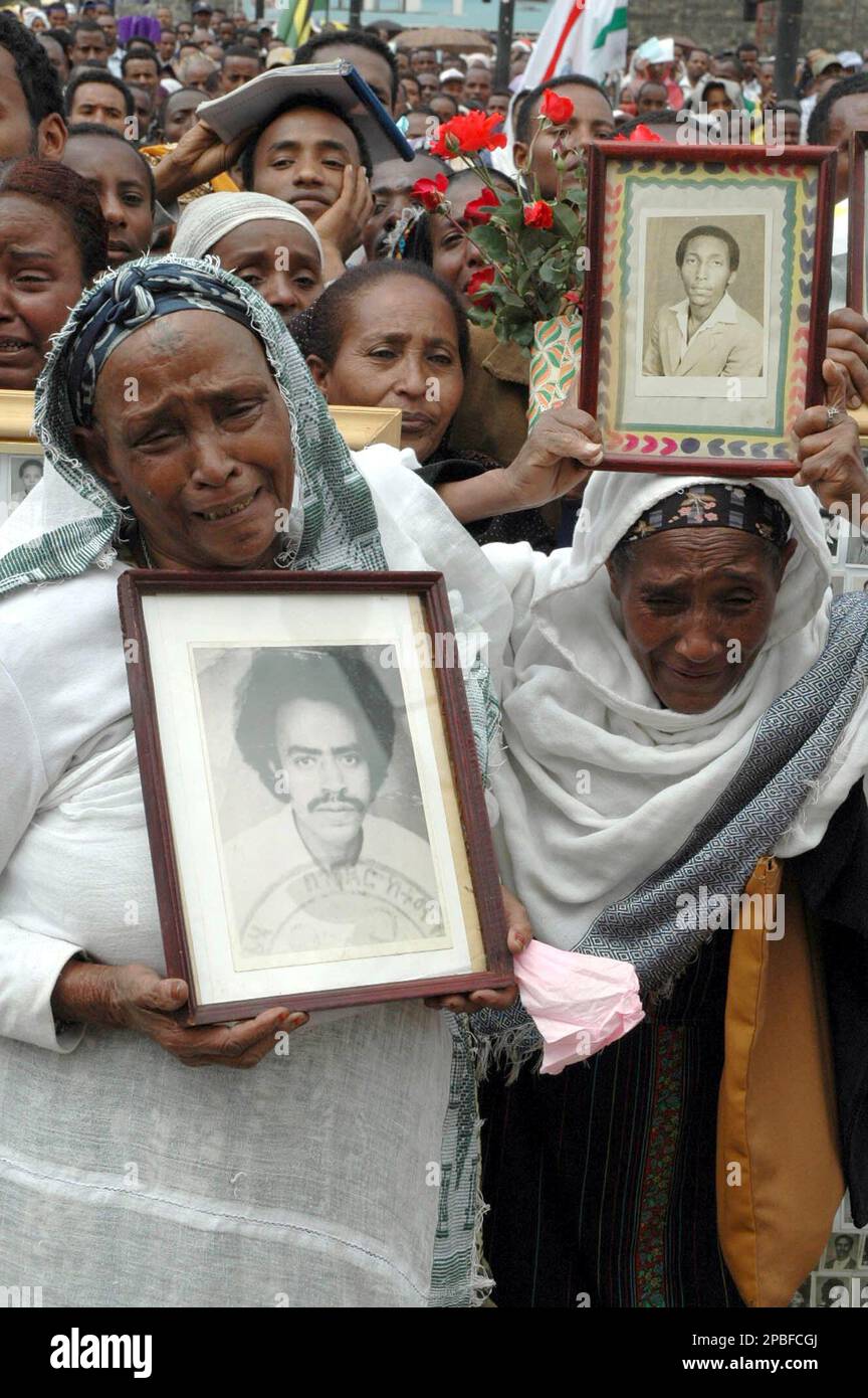 Women hold photos of their loved ones, Sunday, May 27, 2007, who were ...