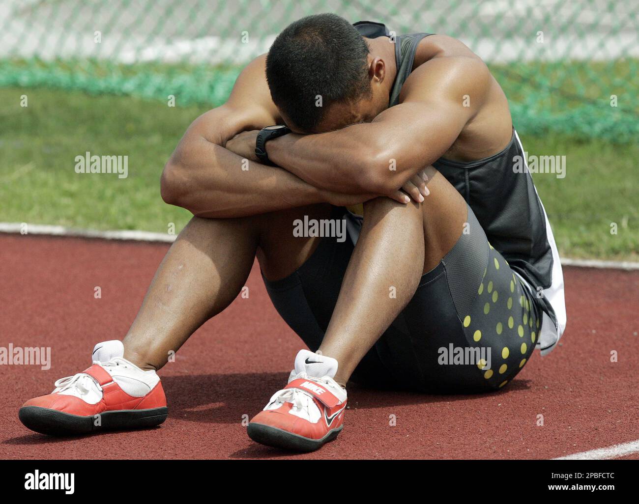 Bryan Clay from the United States sits on the ground after a poor ...