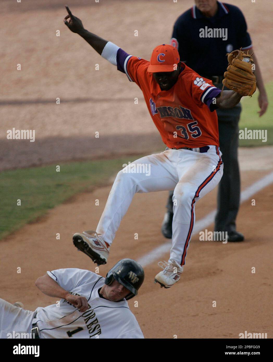 Wake Forest's Dustin Hood, bottom, is safe at third base on an error as ...