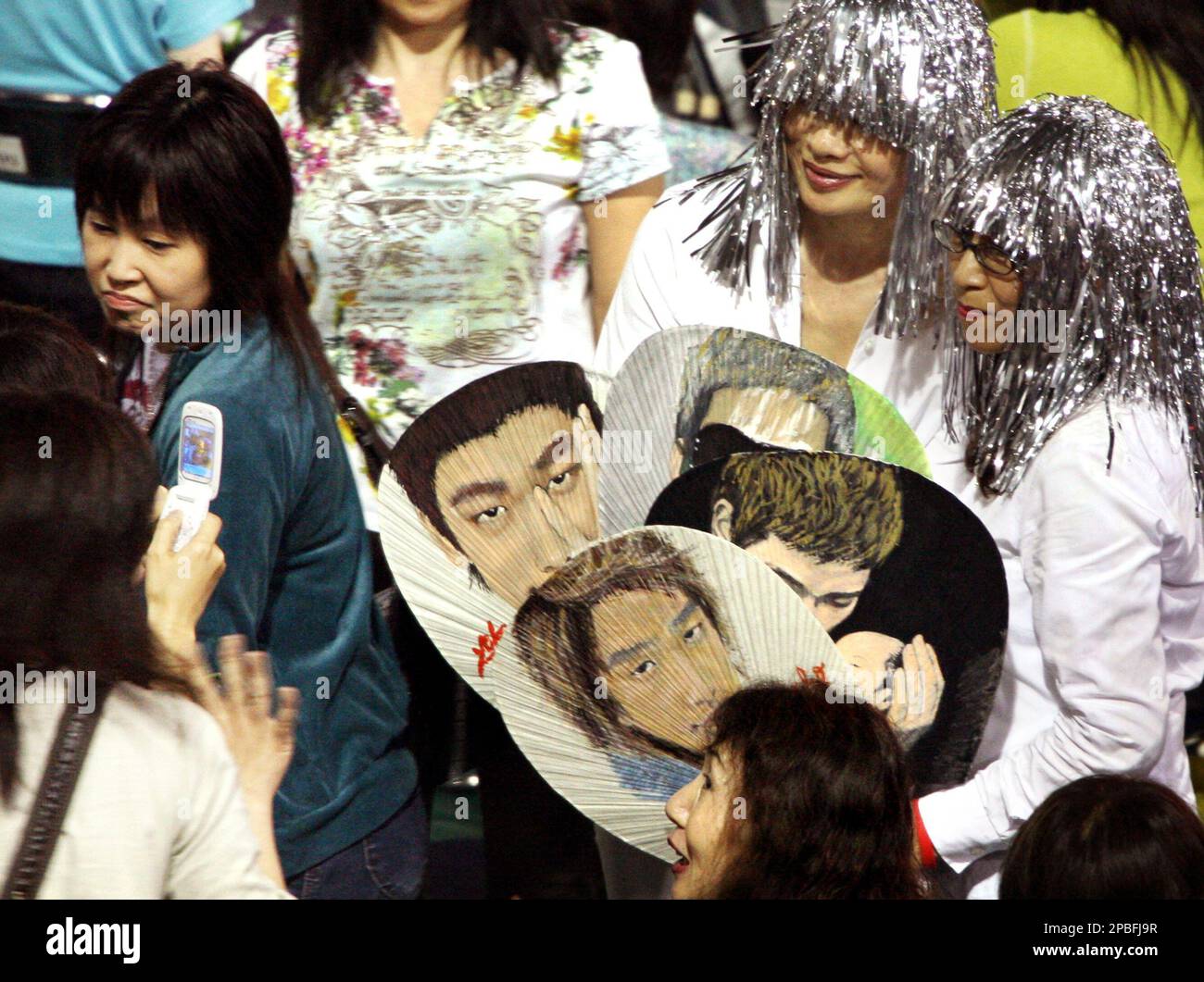 South Korean pop idol Rain fans in silver wigs holding hand made fans ...