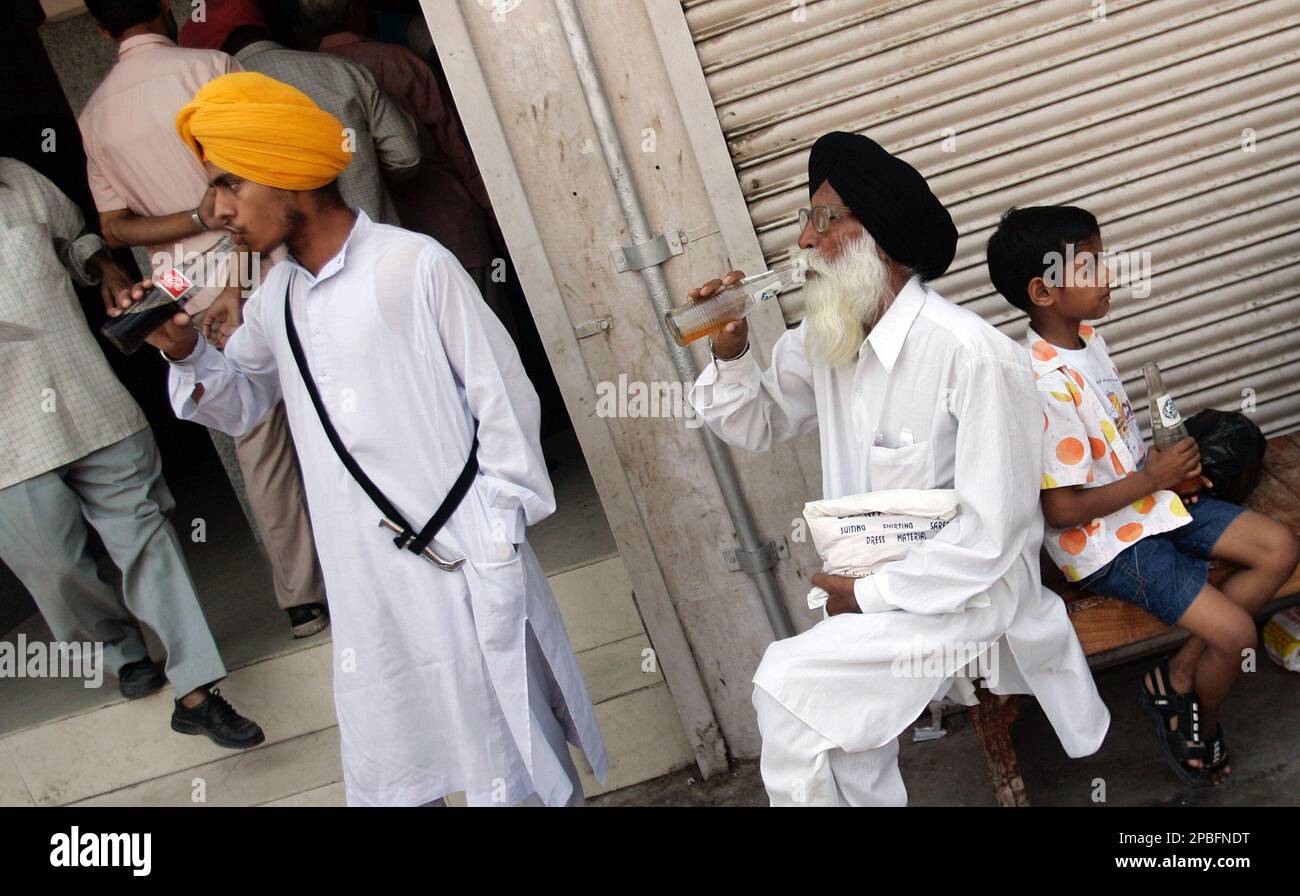 Sikh devotees drink aerated water to gain respite from the heat ...