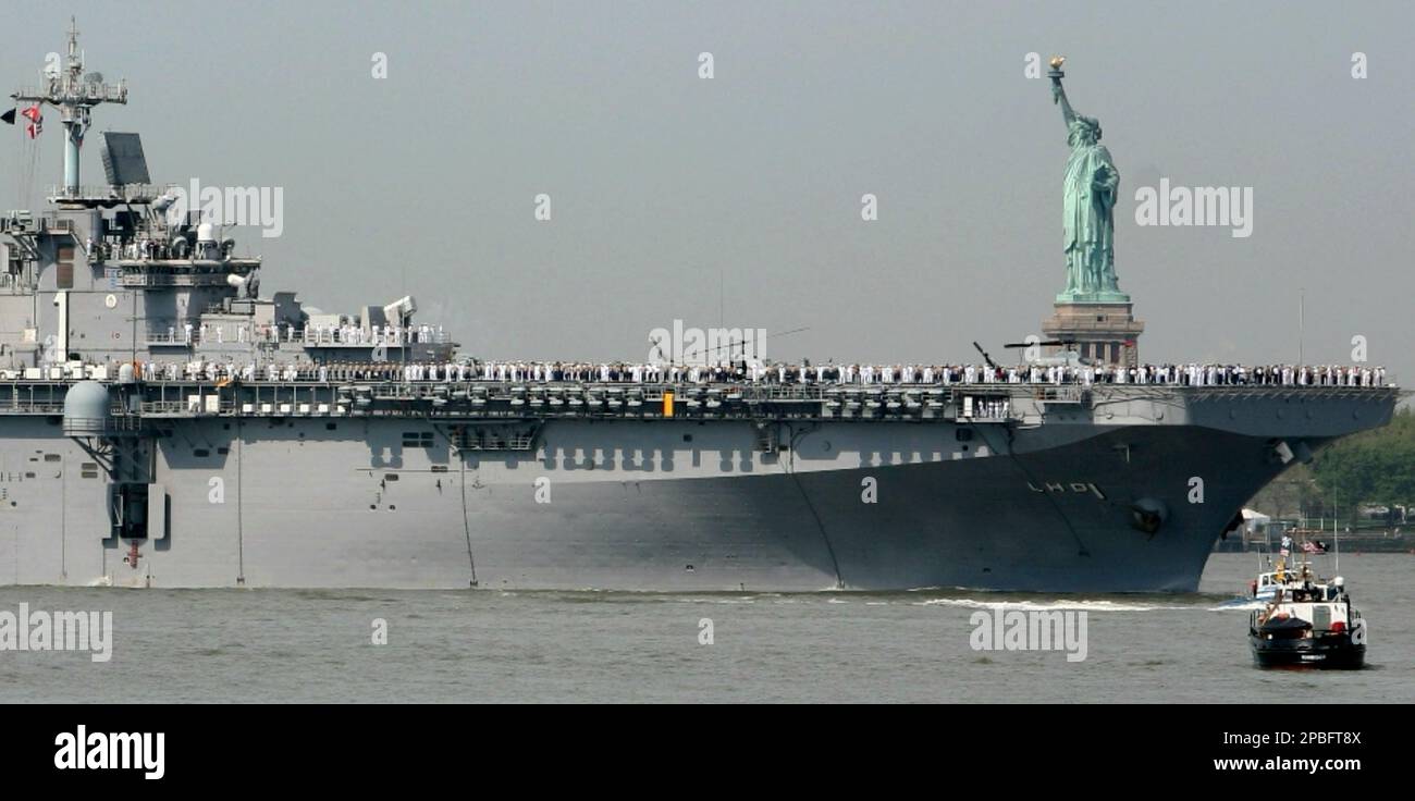 Sailors and Marines line the railing on the The multi-purpose ...