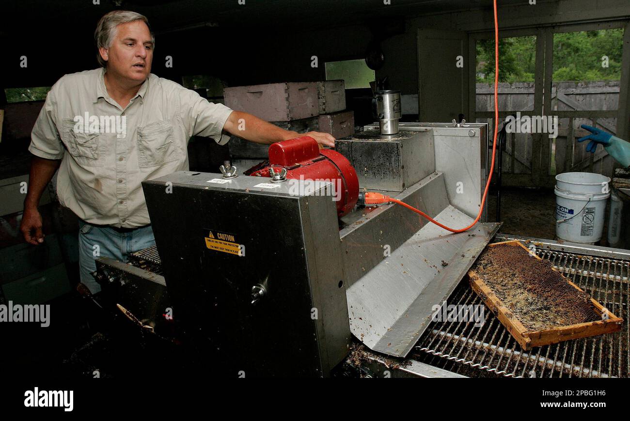 Ben Lanier puts honey frames from his bee hives throught an uncapper ...
