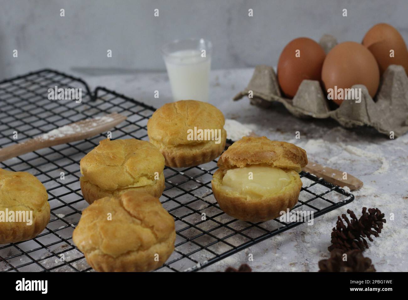 a traditional cake from Indonesia called kue sus filled with cream puffs. served on a cake rack ...