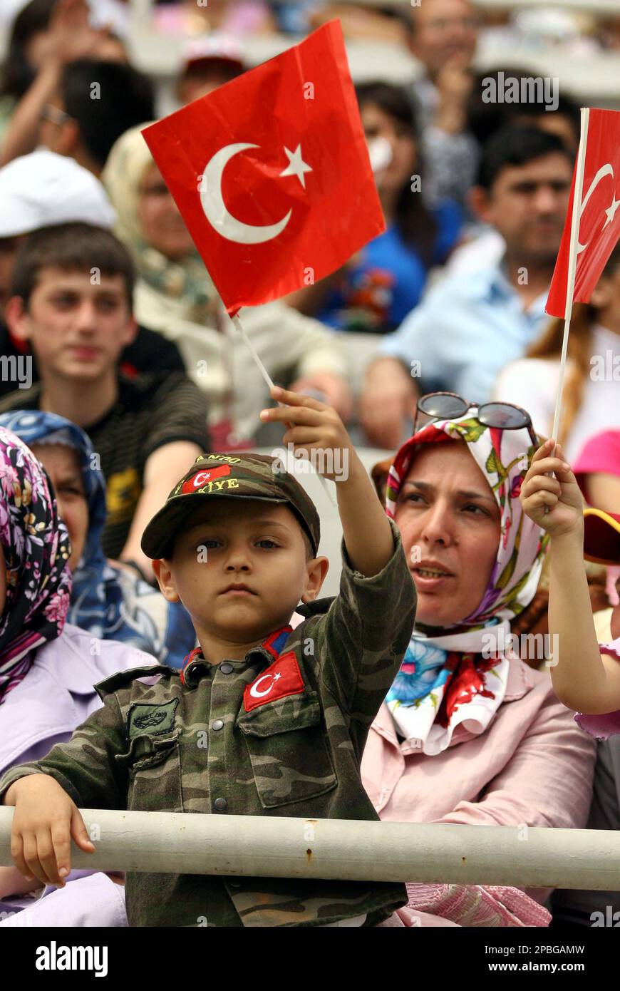 A boy wearing a military uniform waves a Turkish flag during the Youth ...