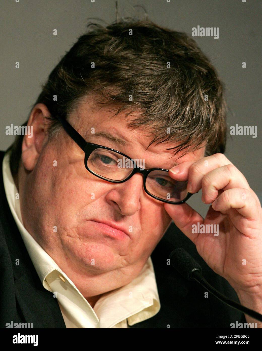 American director Michael Moore adjusts his glasses during a press ...