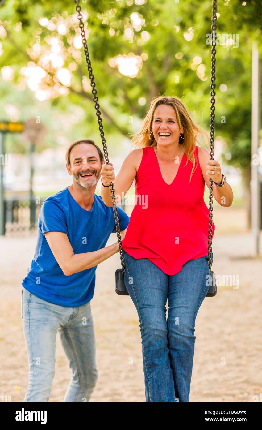 married mature 50s couple enjoy happy in playground swing. Seniors ...