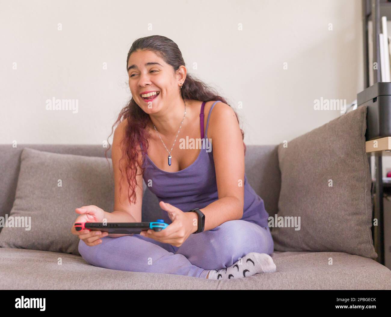 Latin woman playing happy game portable console. generation z gamer ...
