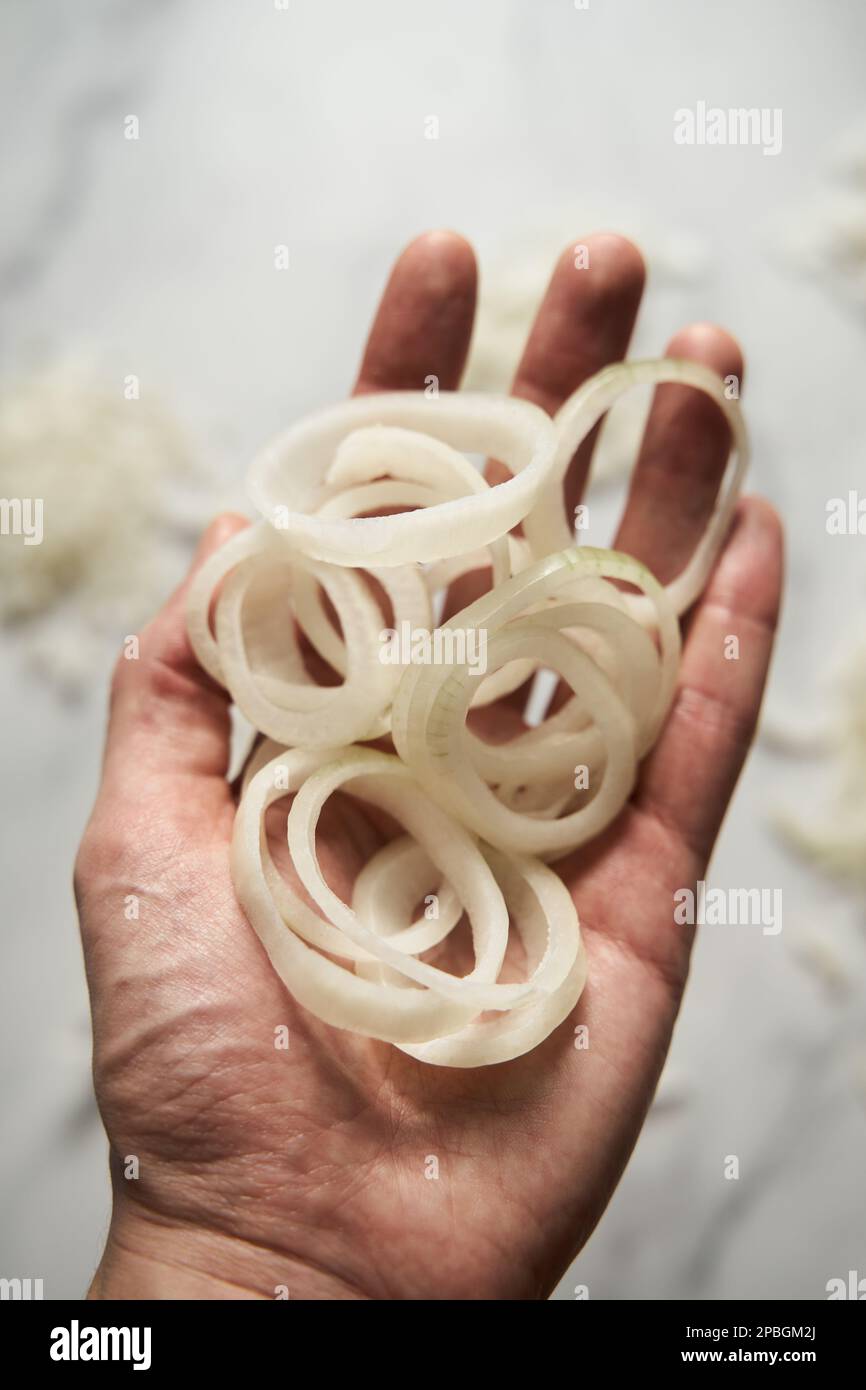 Ring sliced onions on mans hand. Photo show how does onion sliced into ...