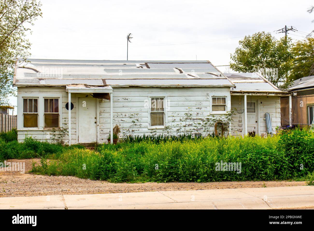 Abandoned Home In Disrepair With Overgrown Weeds Stock Photo - Alamy