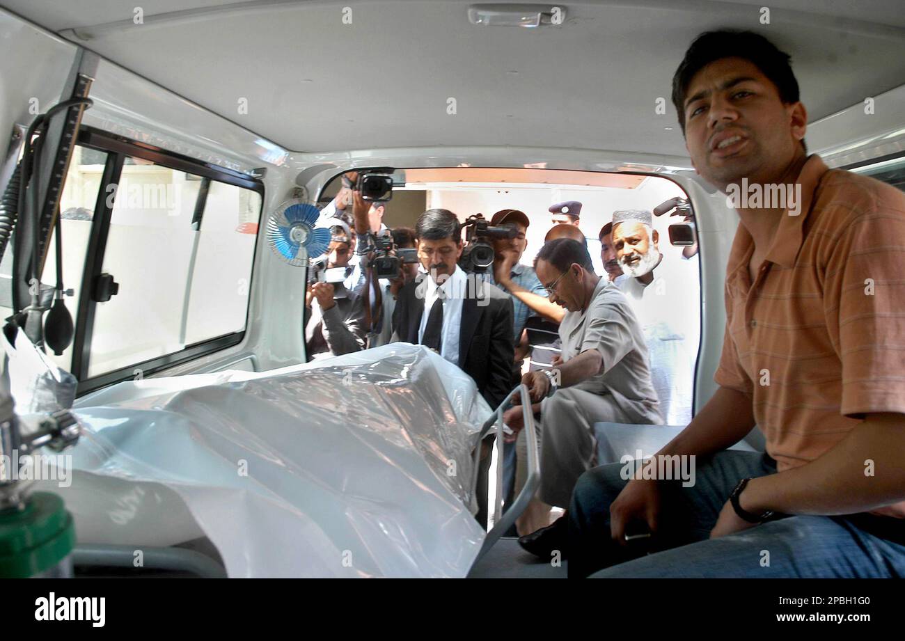 An unidentified relative sits beside the dead body of Syed Hamid Raza ...