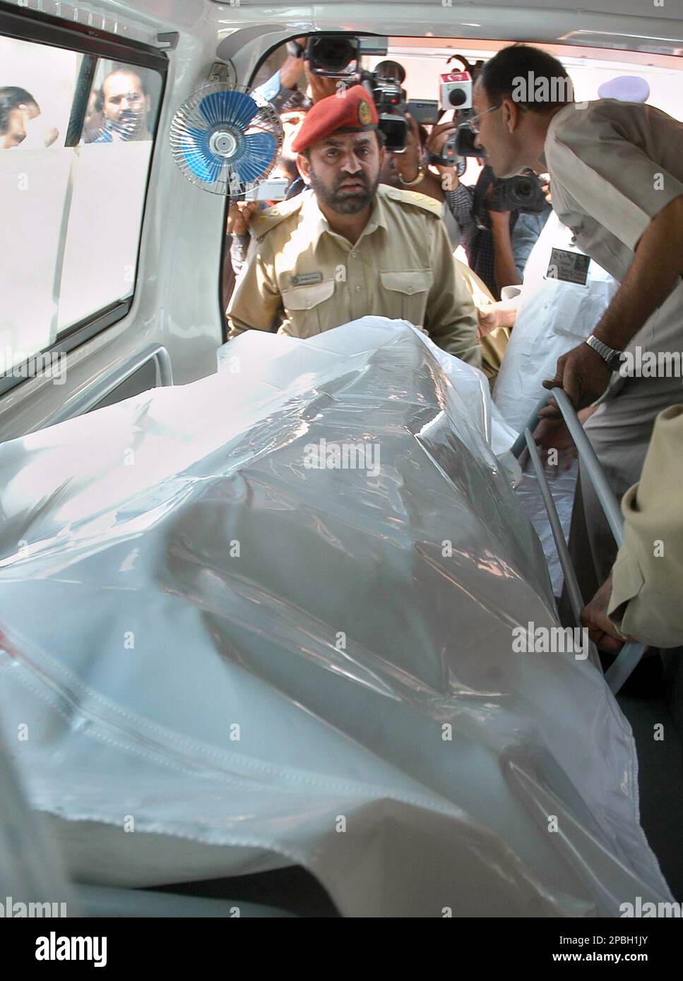 Pakistani paramedic staff load the dead body of Syed Hamid Raza, a ...
