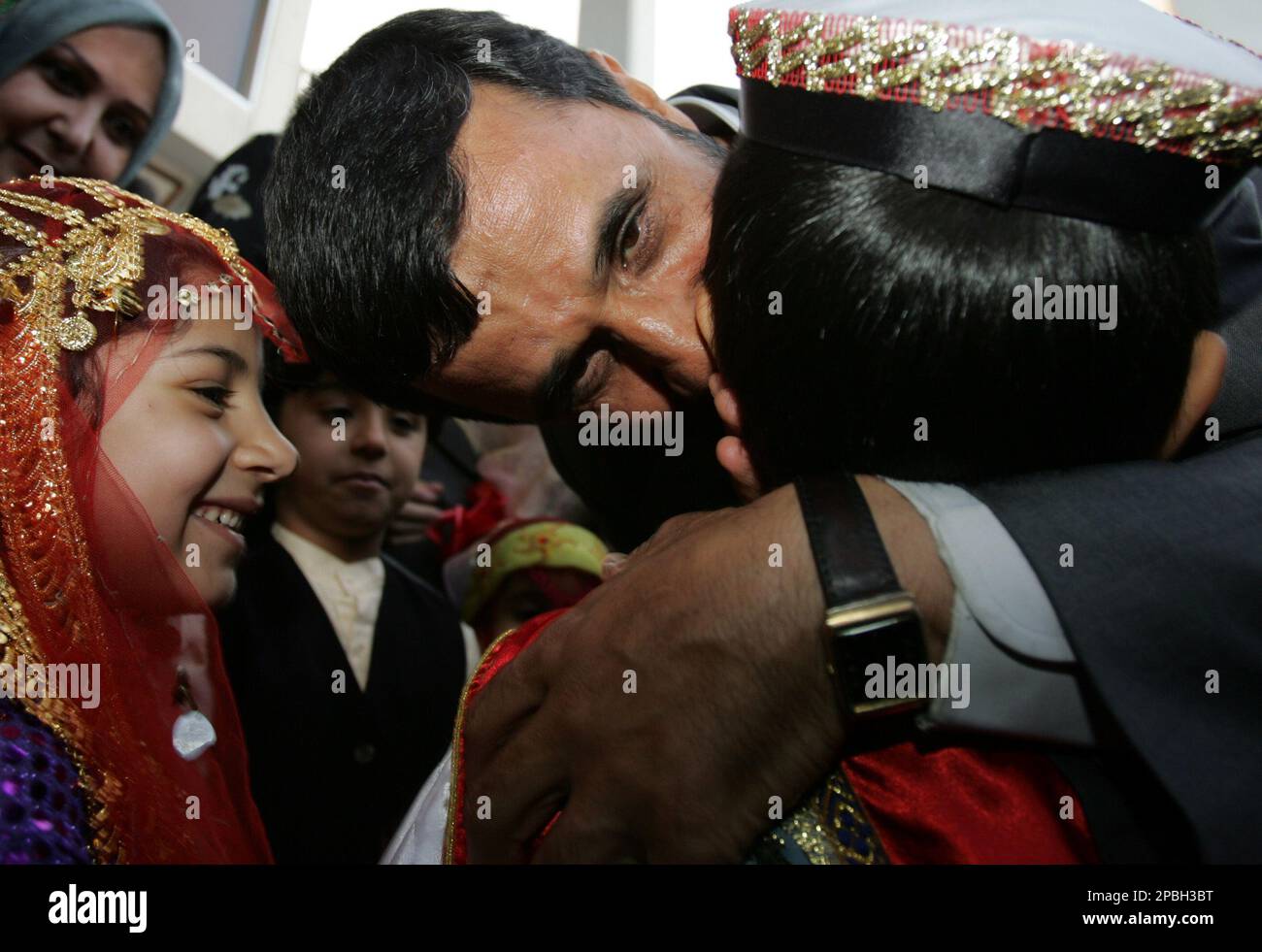 Iran's President, Mahmood Ahmadinejad whispers in the ear of an Iranian ...