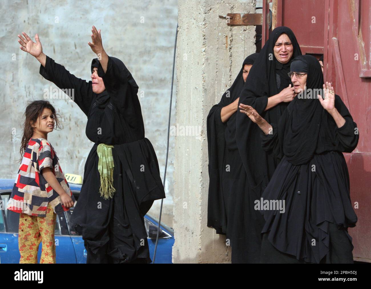 Iraqi women react during funeral for the three members of a family ...