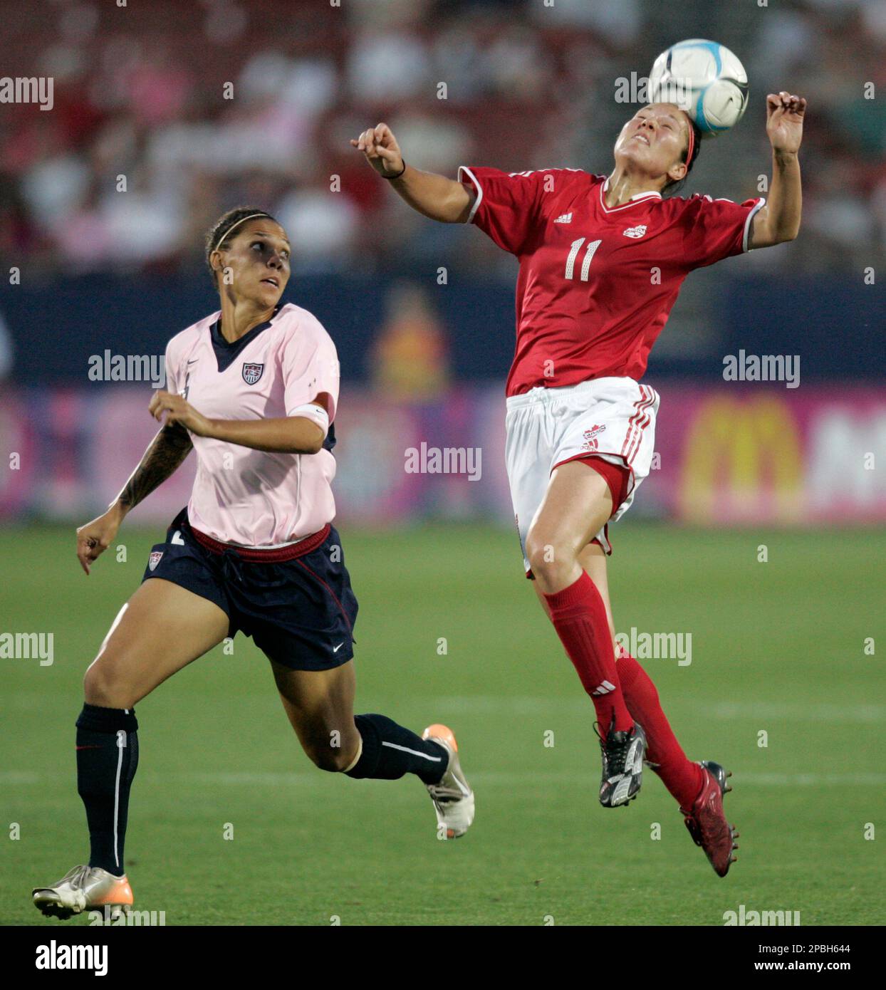 U.S. player Carli Lloyd, left, looks on as Canada's Randee Hermus heads ...