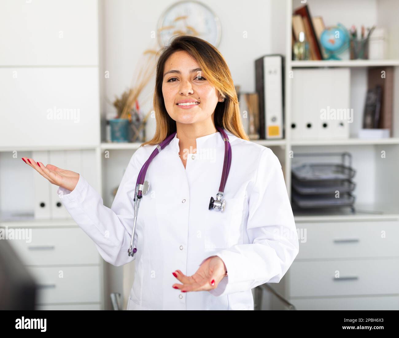 Female doctor welcoming to clinic Stock Photo - Alamy