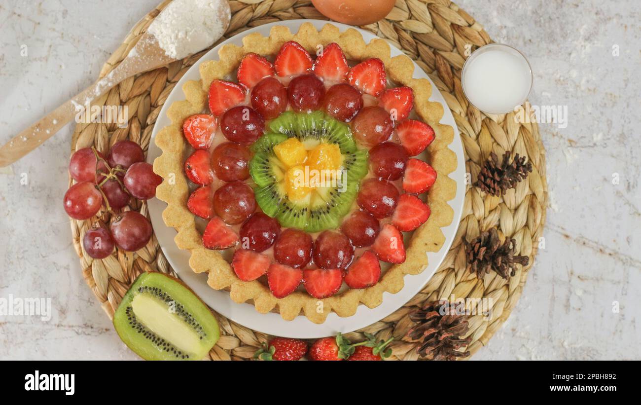 big fruit pie with toppings of strawberries, grapes, kiwi and pineapple ...