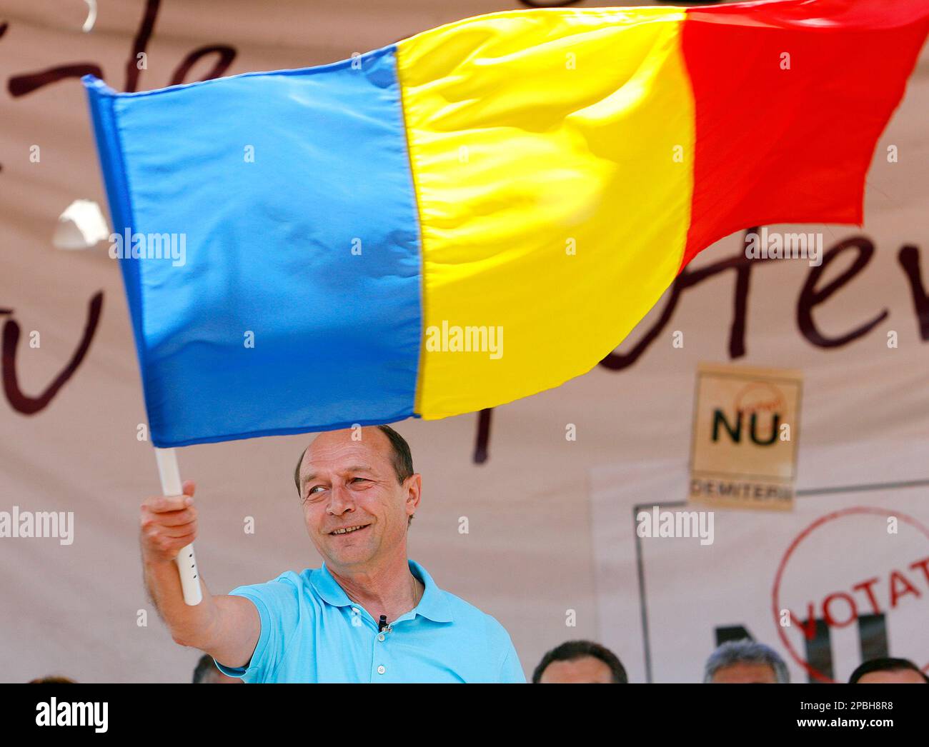 Romania's suspended President Traian Basescu waves a Romanian flag ...