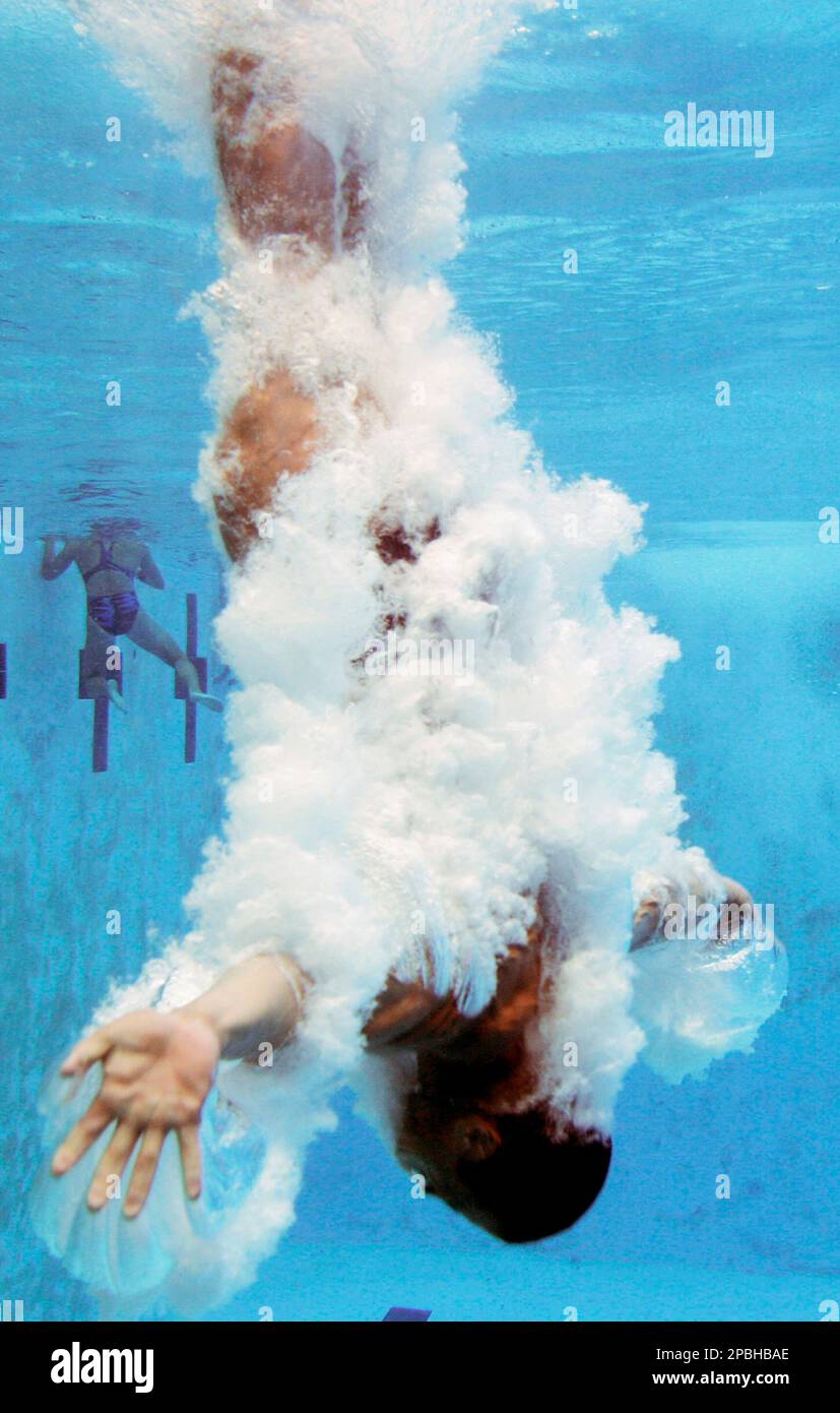 A diver enters the water from the 3m springboard during practice Friday ...
