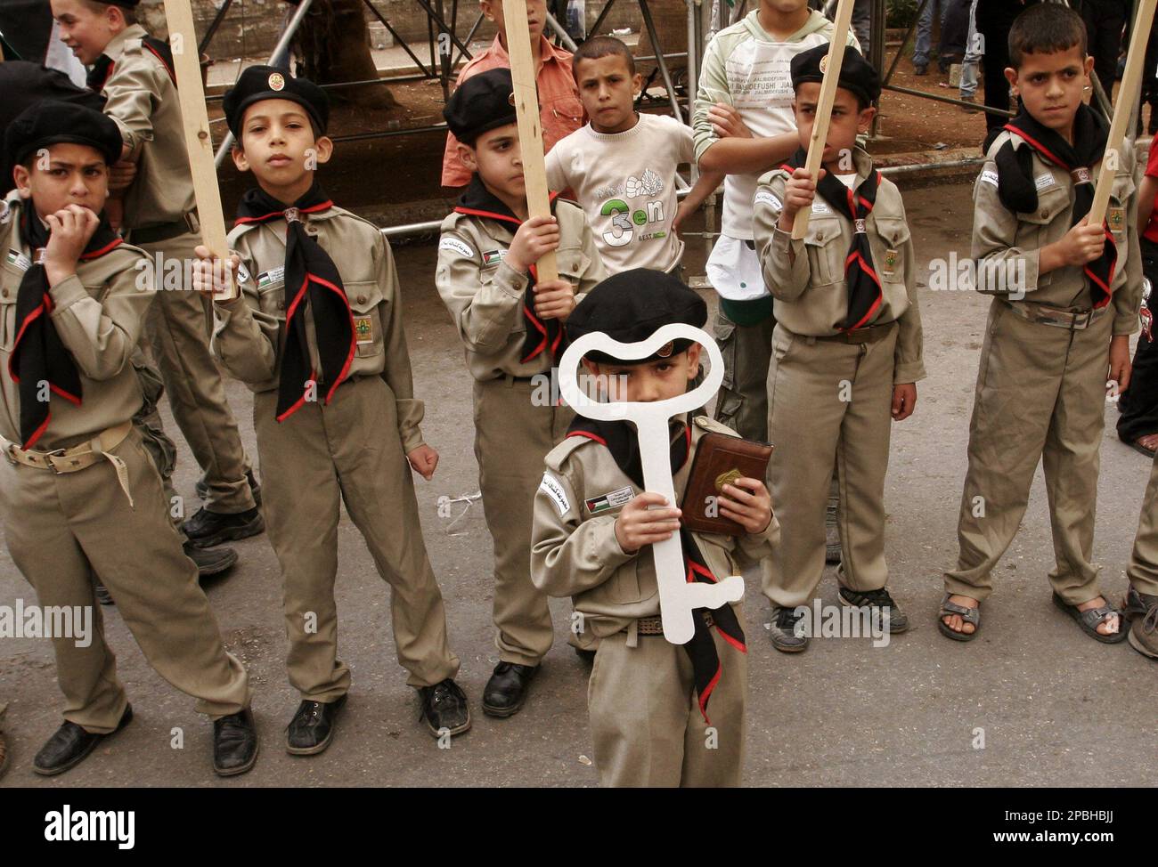A Palestinian boy scout holds a representation of a key during a rally ...